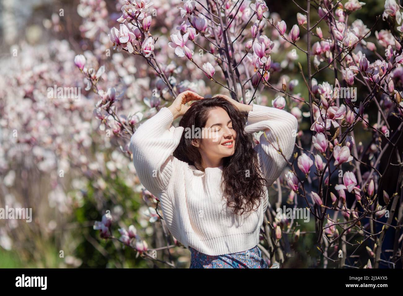 Beautiful girl with flowers of magnolia. Portrait of young smiling ...