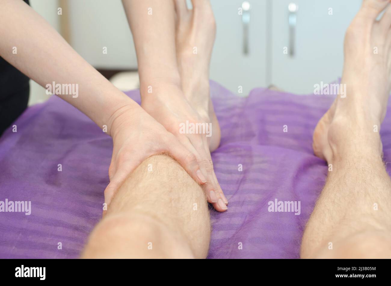 Rehabilitation doctor massages legs after injury. Woman's hands doing ...