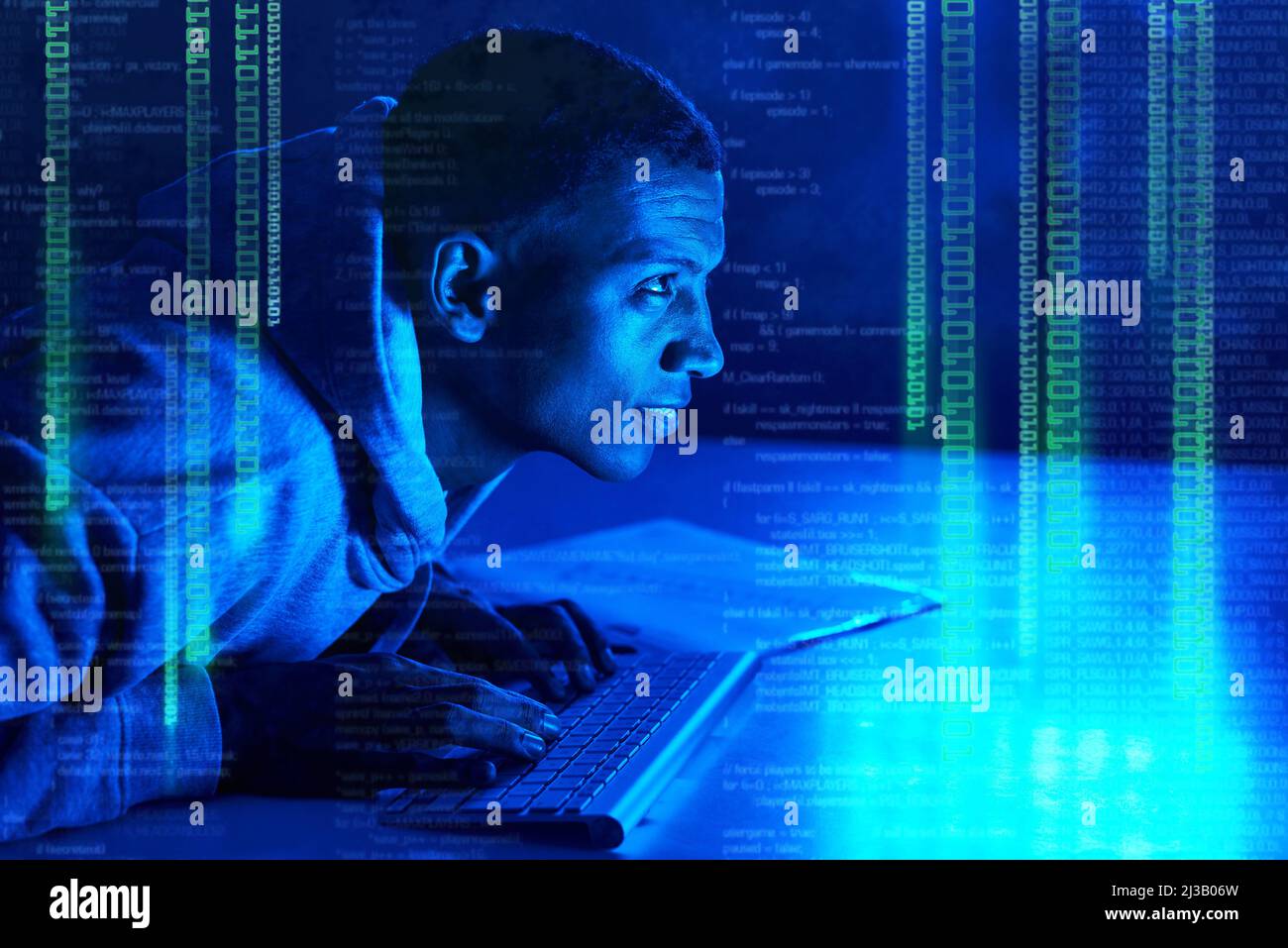 Hes a menace in the cyber world. Shot of a young male hacker cracking a ...
