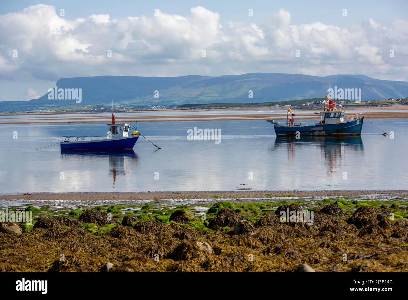 Boat in shallow water with scenic Irish view of Ben Bulben in ...