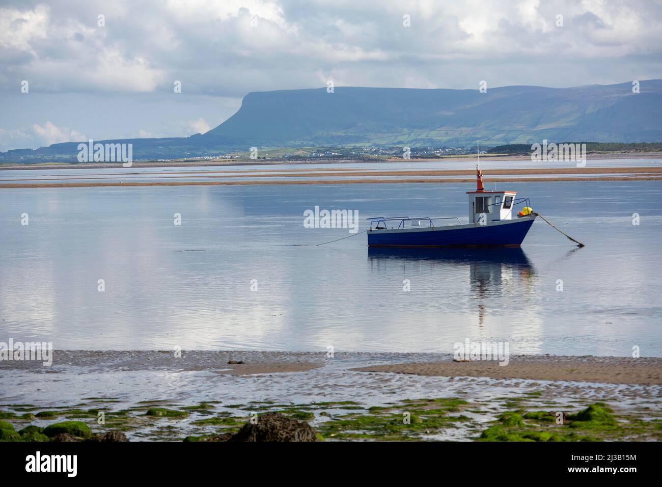 Boat in shallow water with scenic Irish view of Ben Bulben in ...