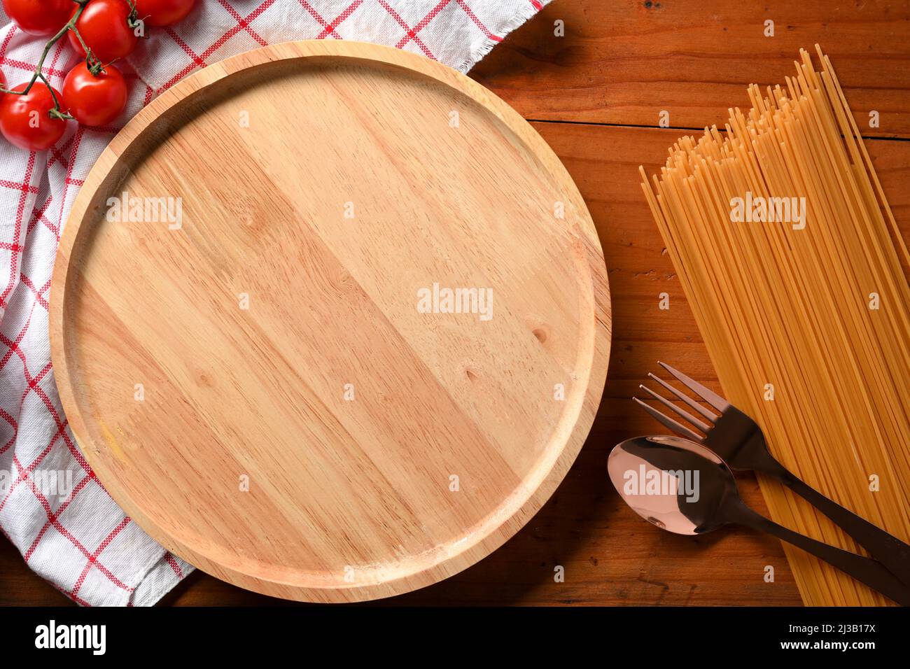 Wood dining table top view with spaghetti ingredients, raw spaghetti ...