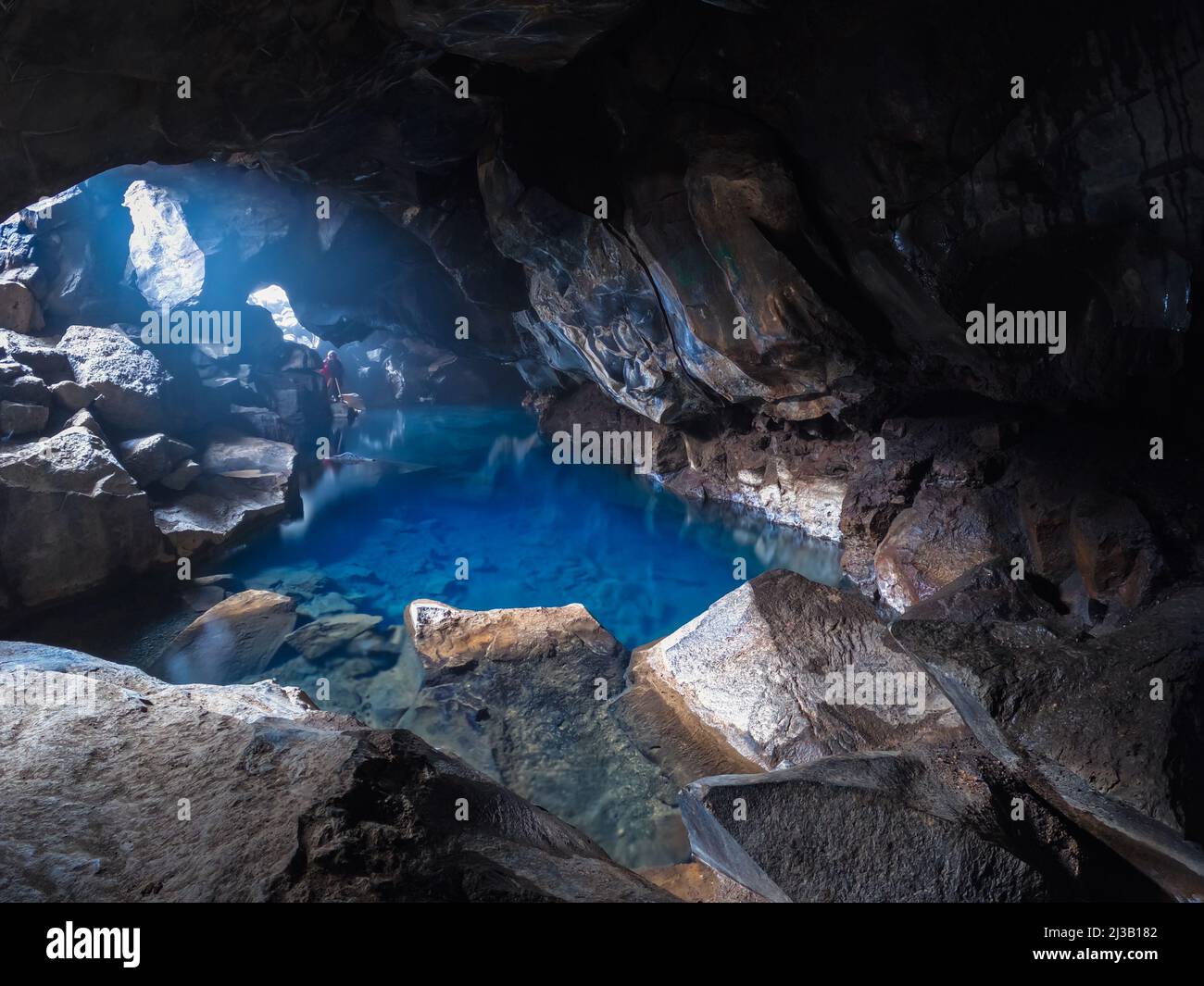 Deep blue lake inside the cave with photographer Stock Photo - Alamy