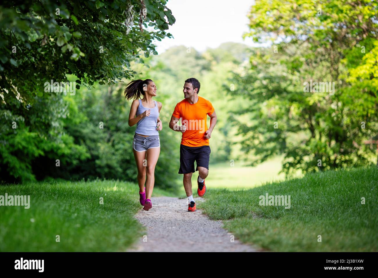 Portrait of happy fit people running together ourdoors. Couple sport ...
