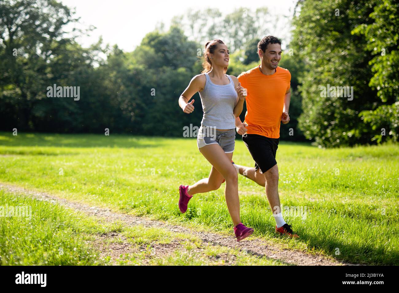 Portrait of happy fit people running together ourdoors. Couple sport ...