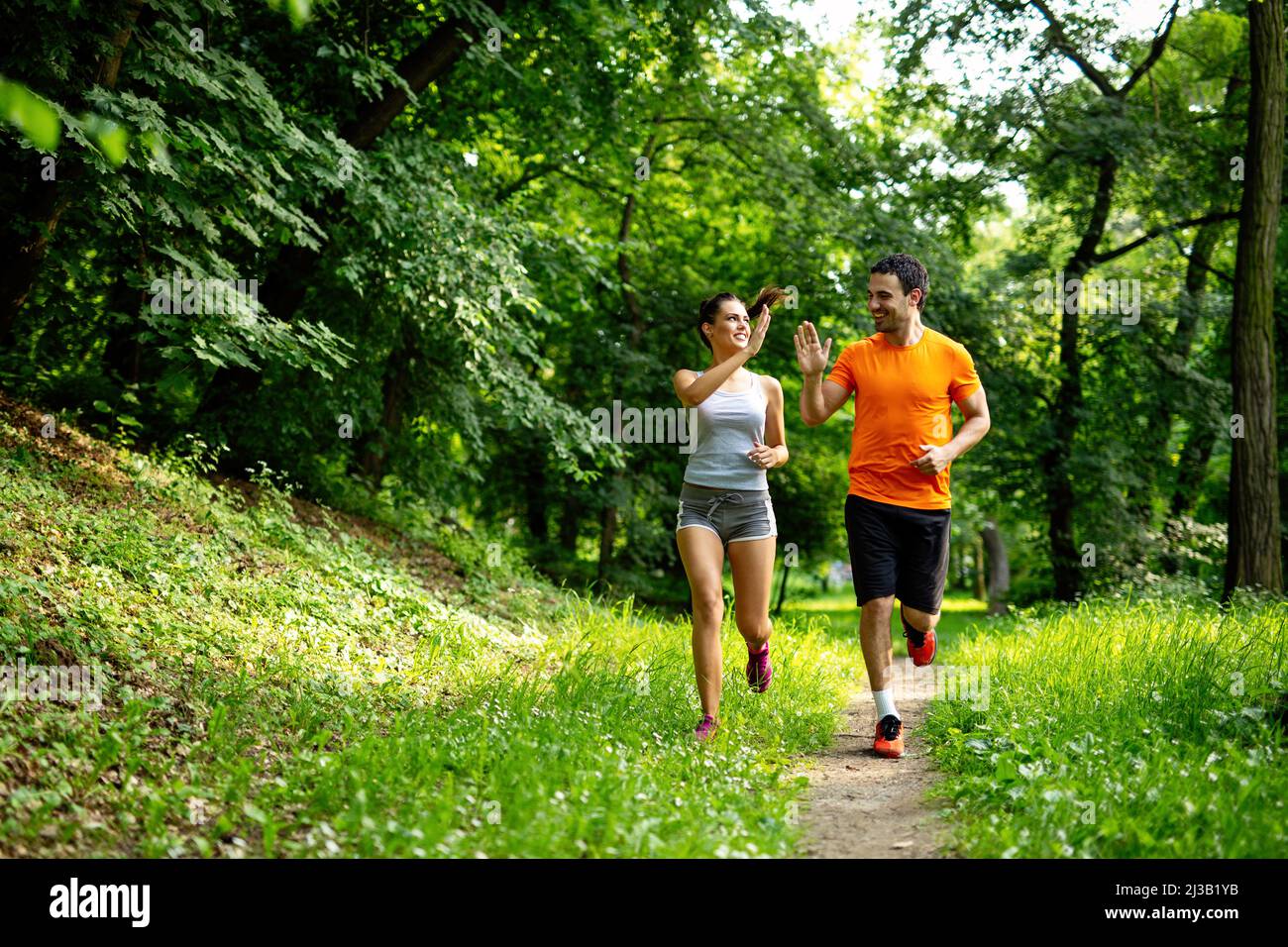 Portrait of happy fit people running together ourdoors. Couple sport ...