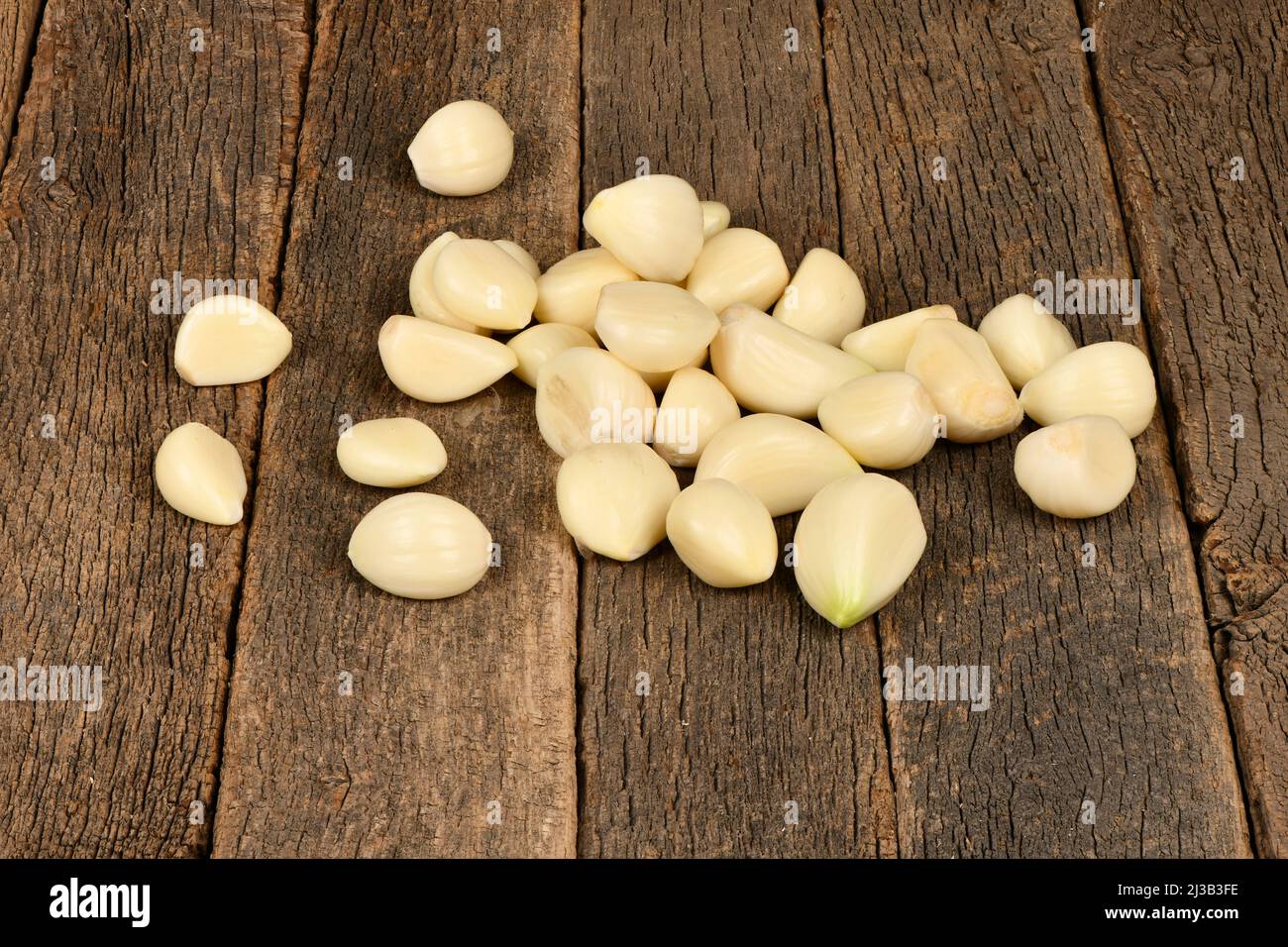 Pile of fresh garlic cloves isolated on dark wood background. High ...
