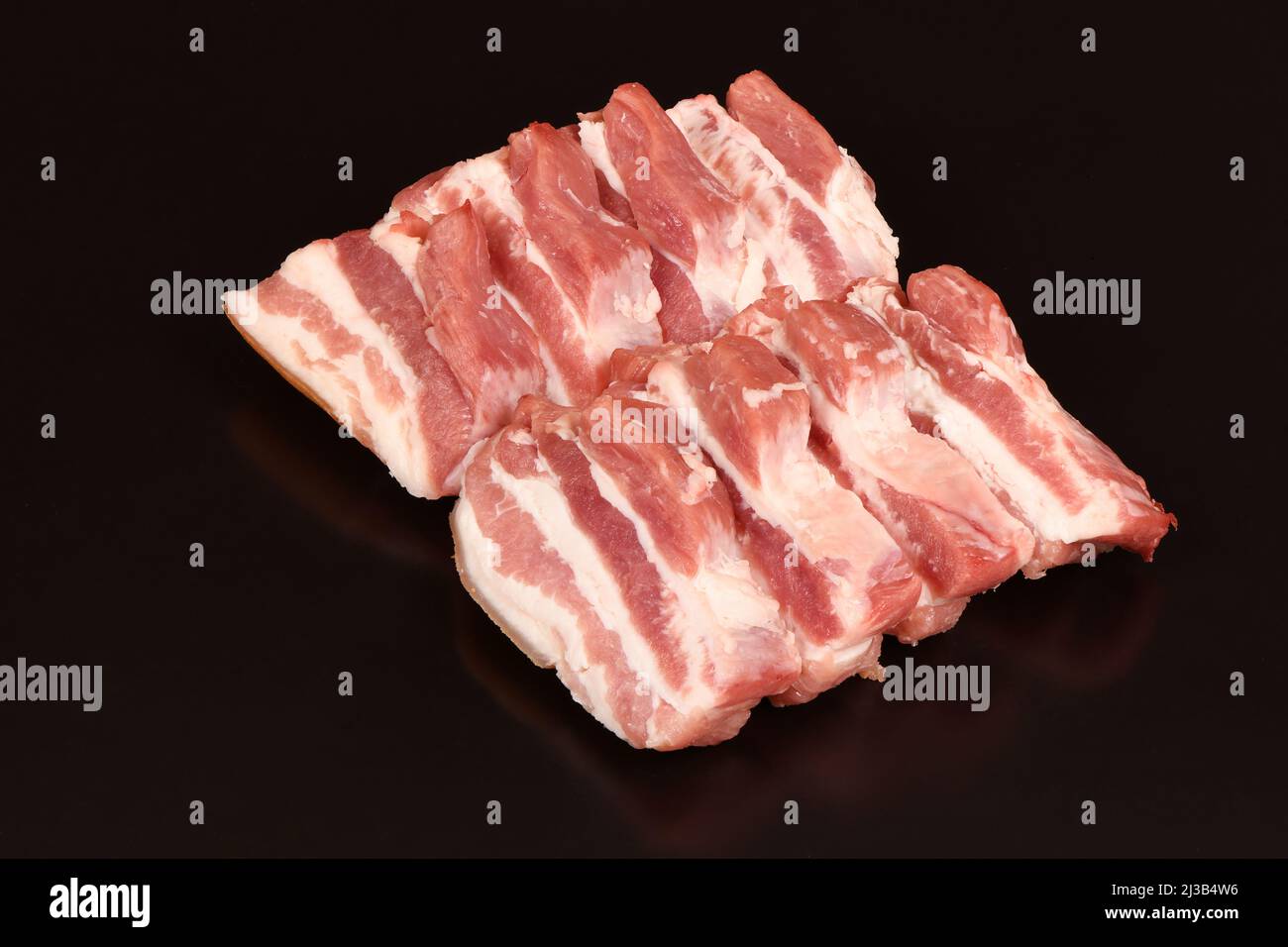 Fresh pork sliced small portions. Raw bacon on black background. High ...