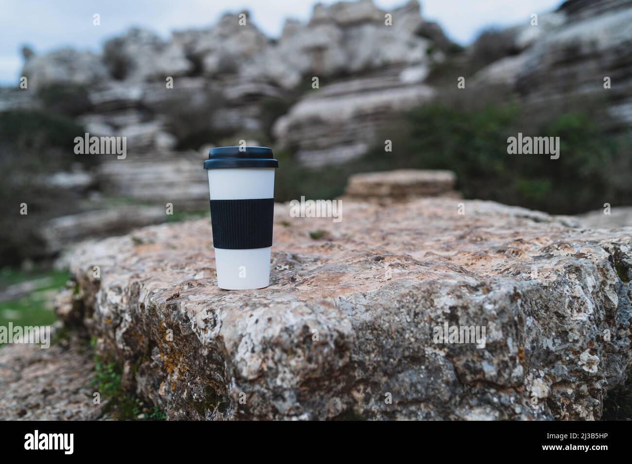 A close-up shot of a cup of coffee on a rock during daytime with ...