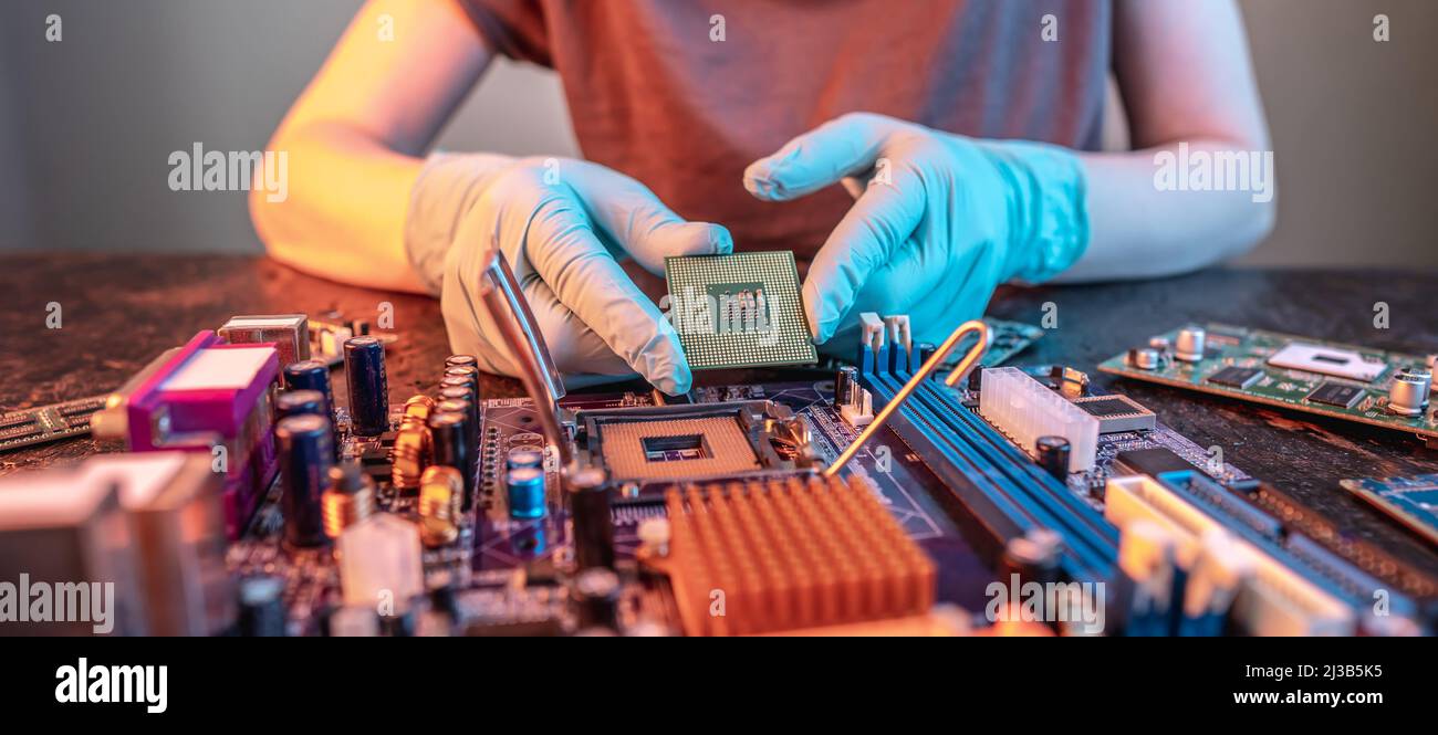 The engineer's gloved hand is holding the CPU chip against the ...