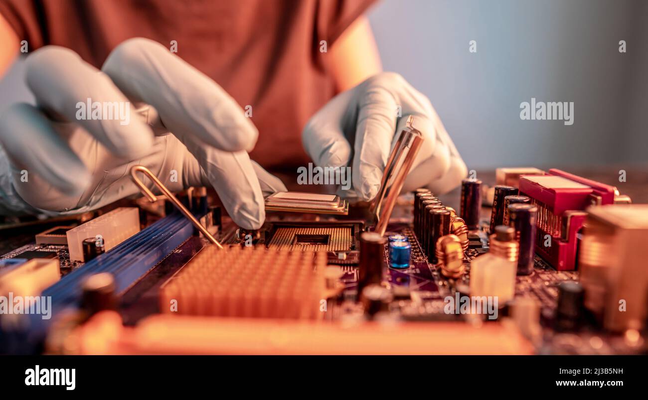 The engineer's gloved hand is holding the CPU chip against the ...