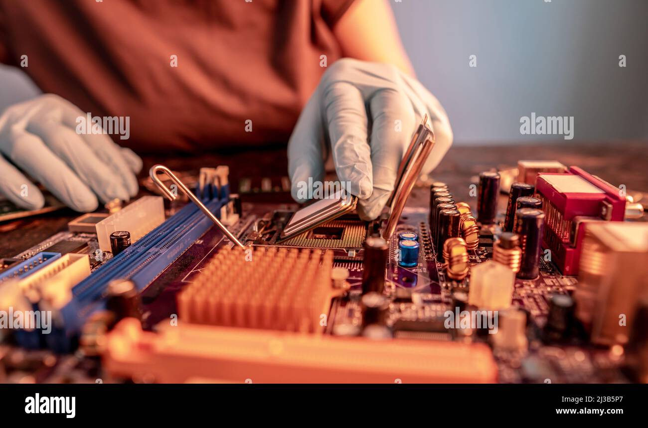 The engineer's gloved hand is holding the CPU chip against the ...