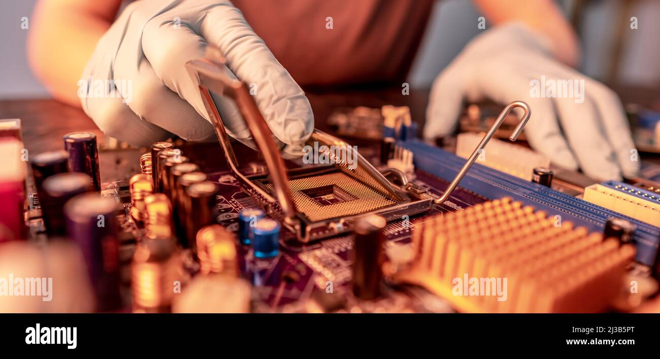 The engineer's gloved hand is holding the CPU chip against the ...
