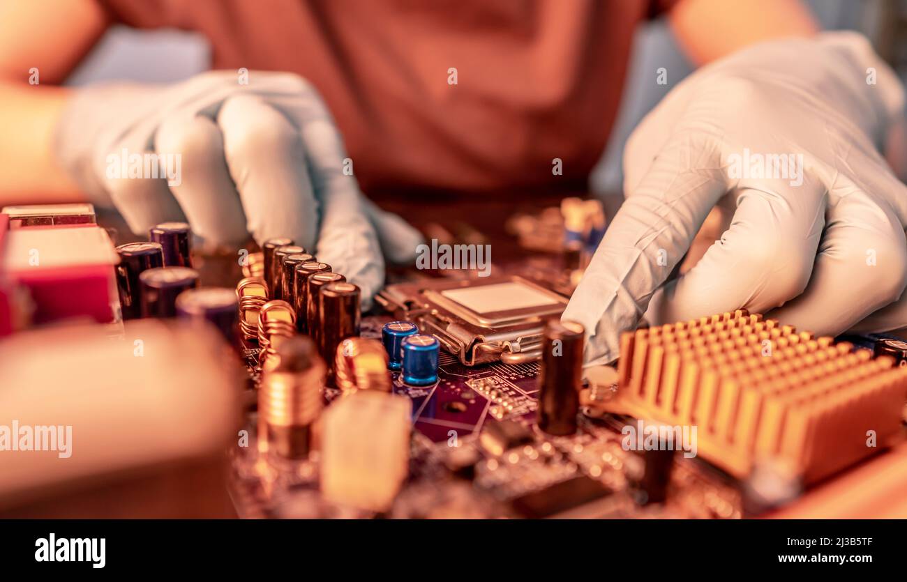 Engineer repairman holding hands in black gloves chip processor, CPU to insert into the socket ...