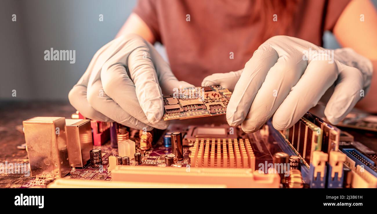The engineer's gloved hand holds the chip board on the background of ...