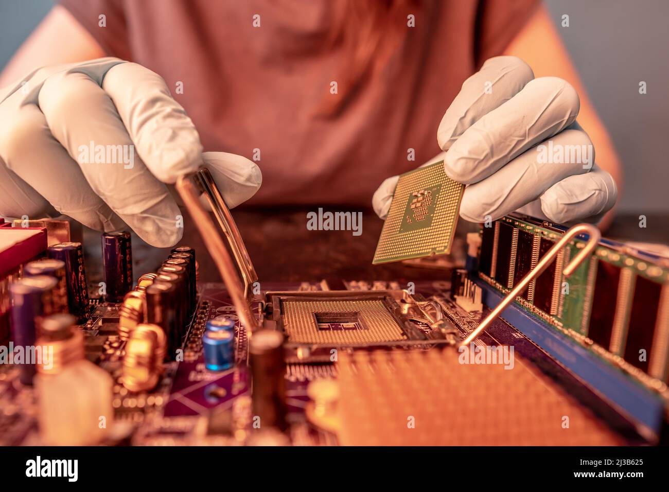 The engineer's gloved hand is holding the CPU chip against the ...