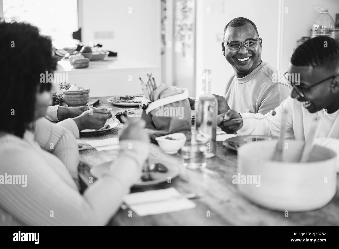 Happy african family eating lunch together at home - Focus on father ...