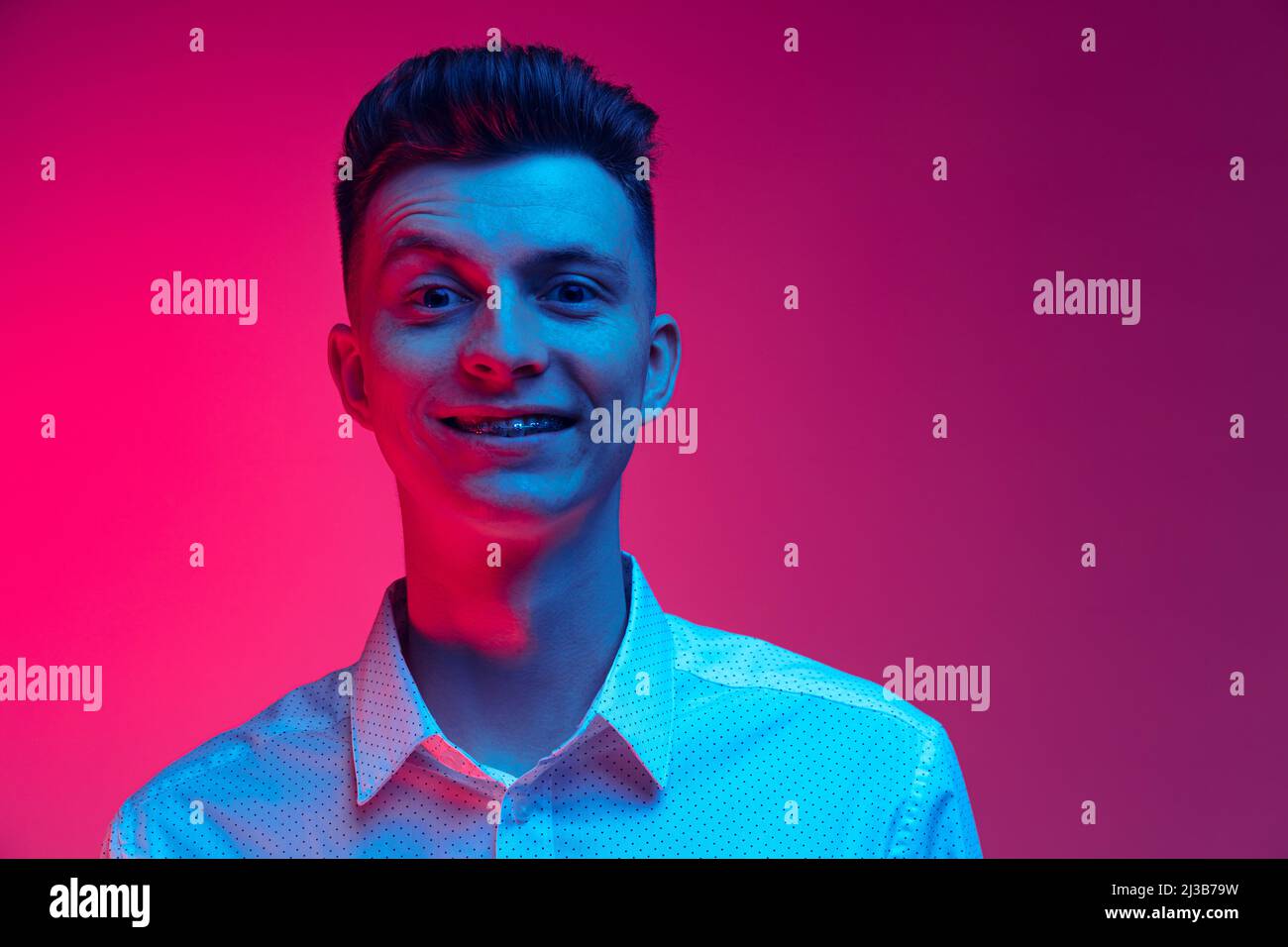 Young happy man in white shirt smiling isolated over magenta color ...