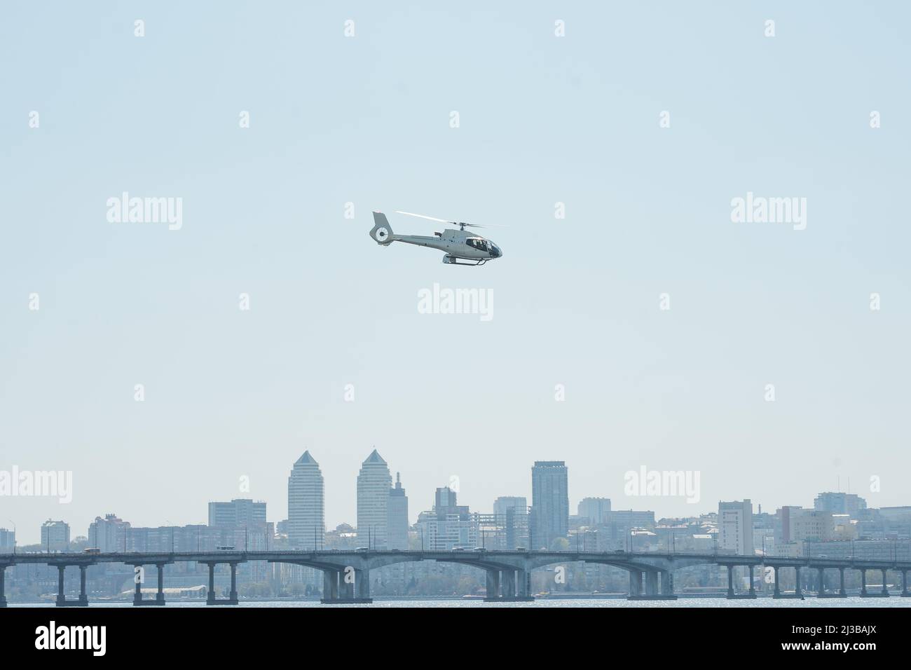 Helicopter flight over the river against a city background with a ...