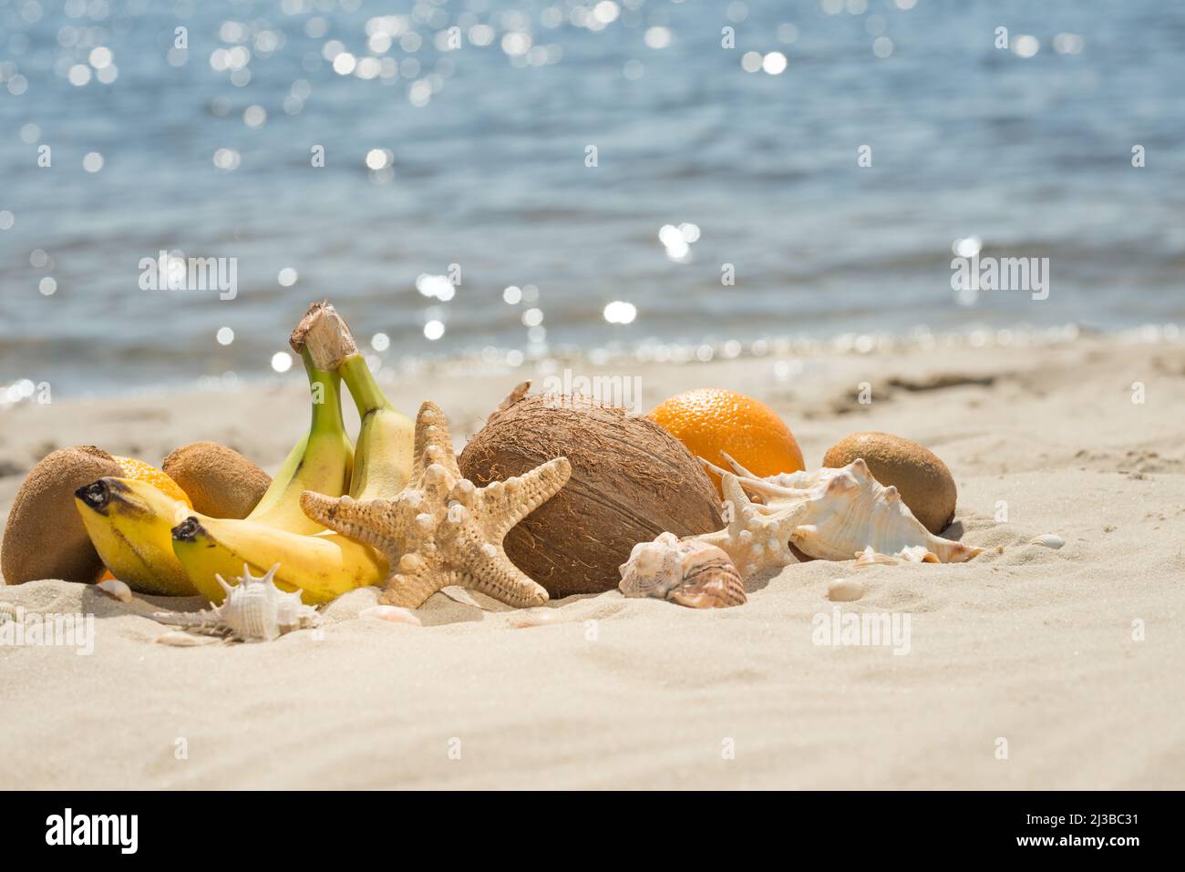 Tropical fruits on white sand on the beach of the sea or ocean Stock ...