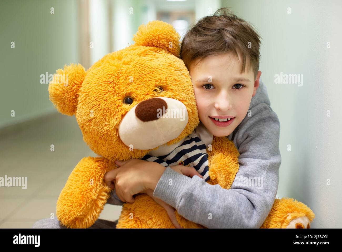 A little boy hugs a fluffy teddy bear Stock Photo - Alamy