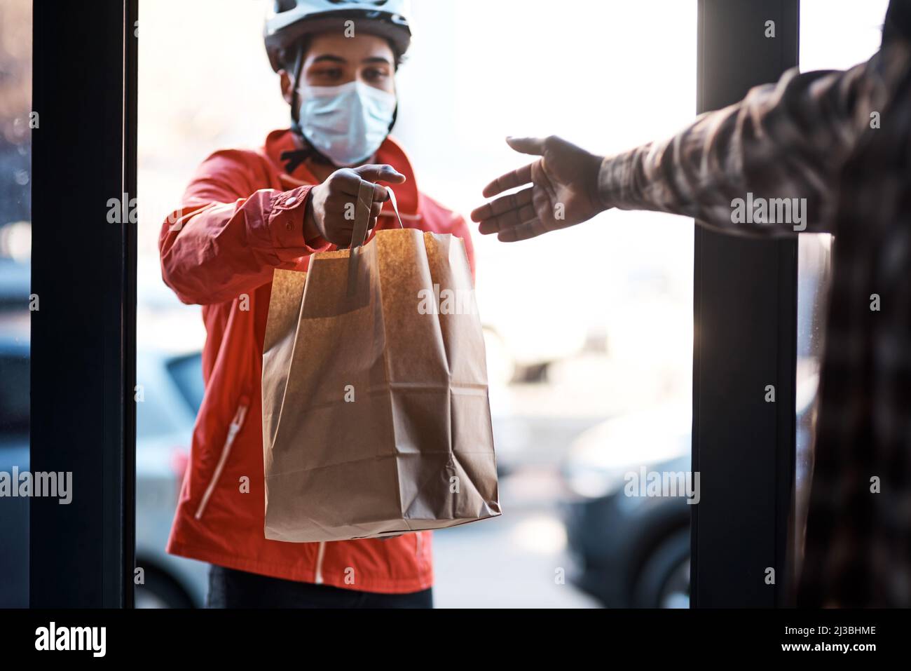 We've got you covered during lockdown. Shot of a masked man delivering ...