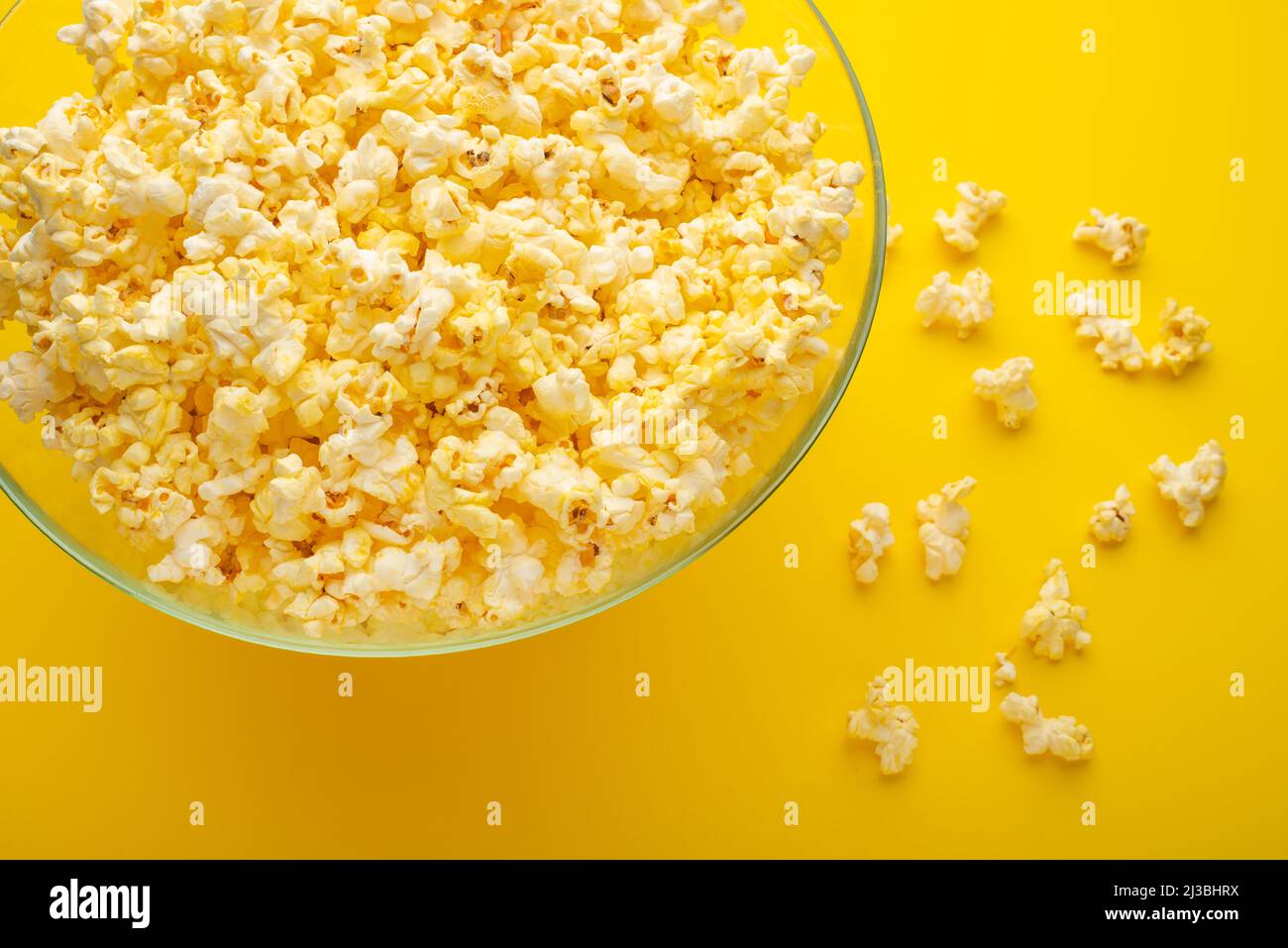 plate with popcorn on a yellow background. layout. top view. concept of ...