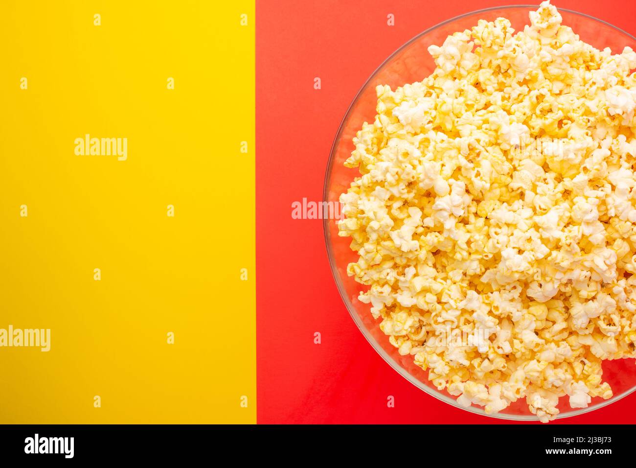 plate with popcorn on yellow and red background. layout. top view ...