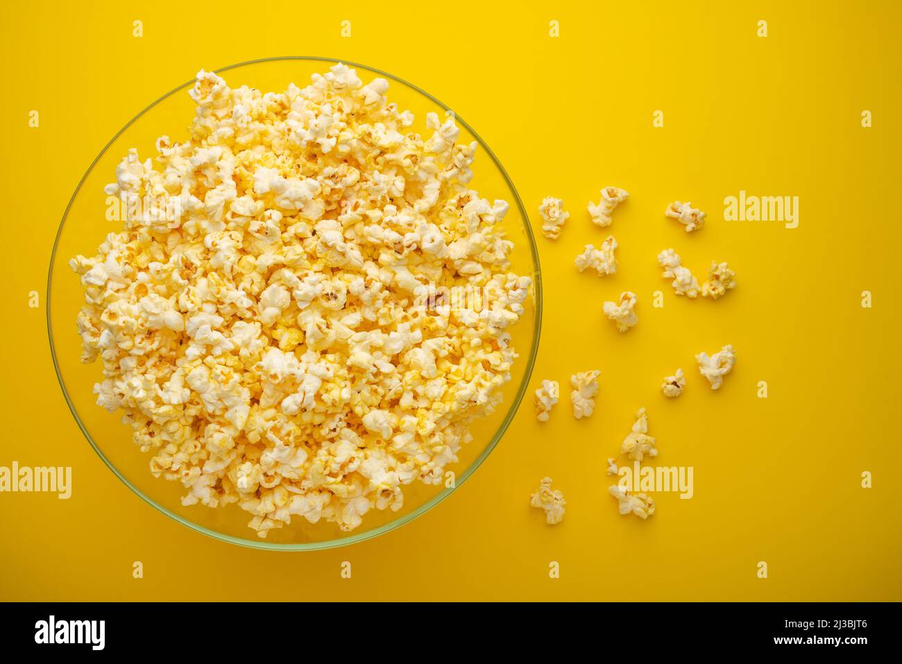 plate with popcorn on a yellow background. layout. top view. concept of ...