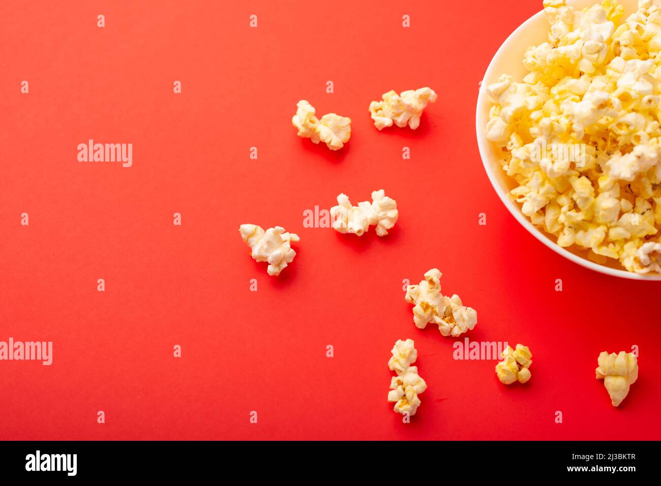 plate with popcorn on a red bright background. movie viewing concept ...