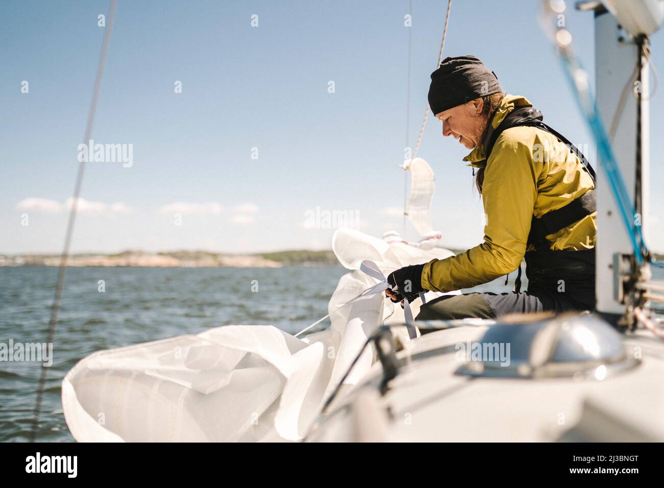 Woman folding sails on boat Stock Photo - Alamy