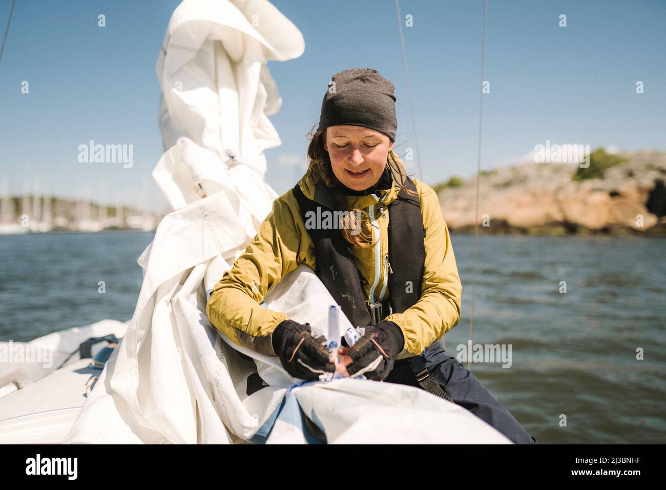 Woman folding sails on boat Stock Photo - Alamy
