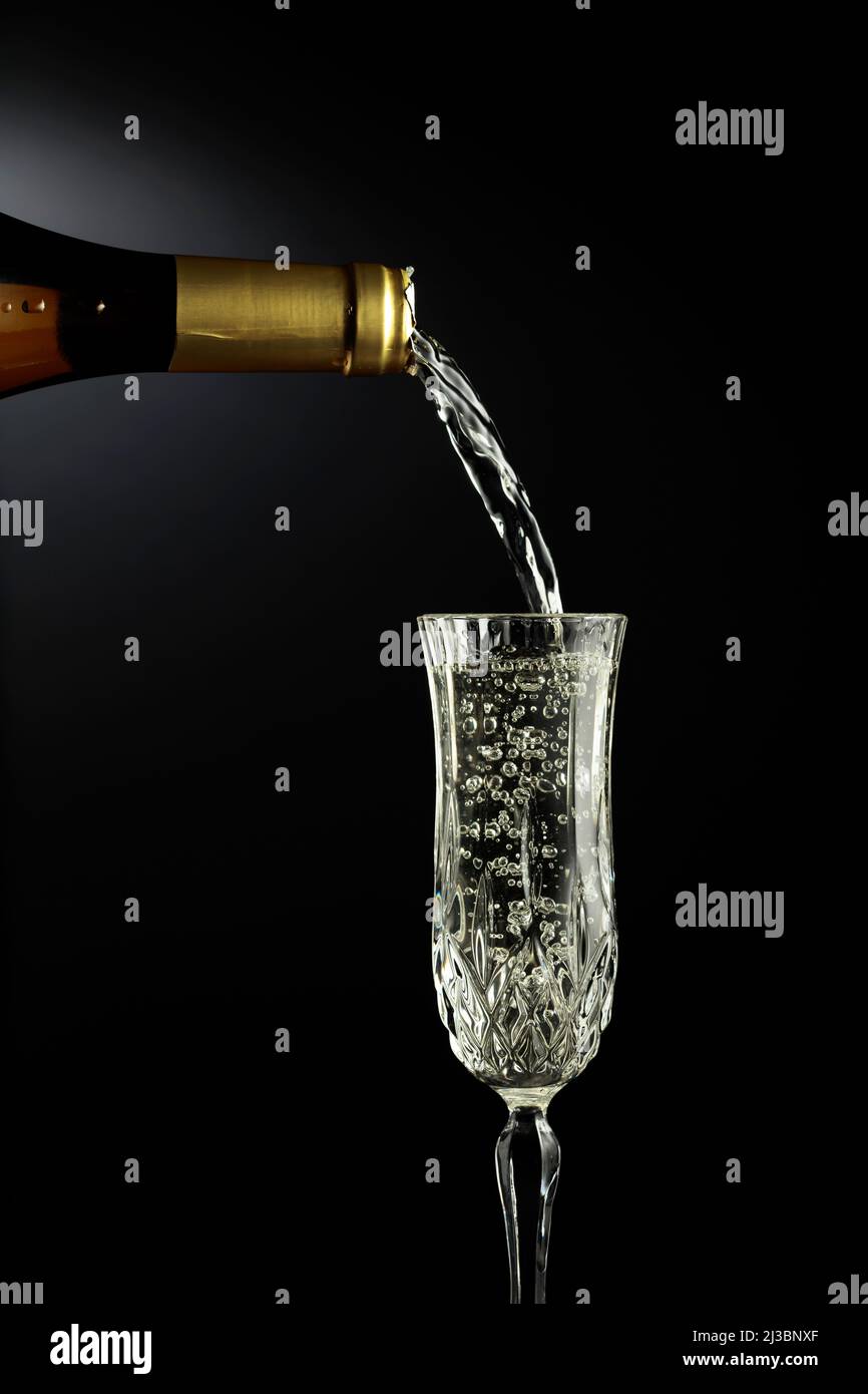 Sparkling wine is poured from a bottle into a glass. Copy space Stock ...