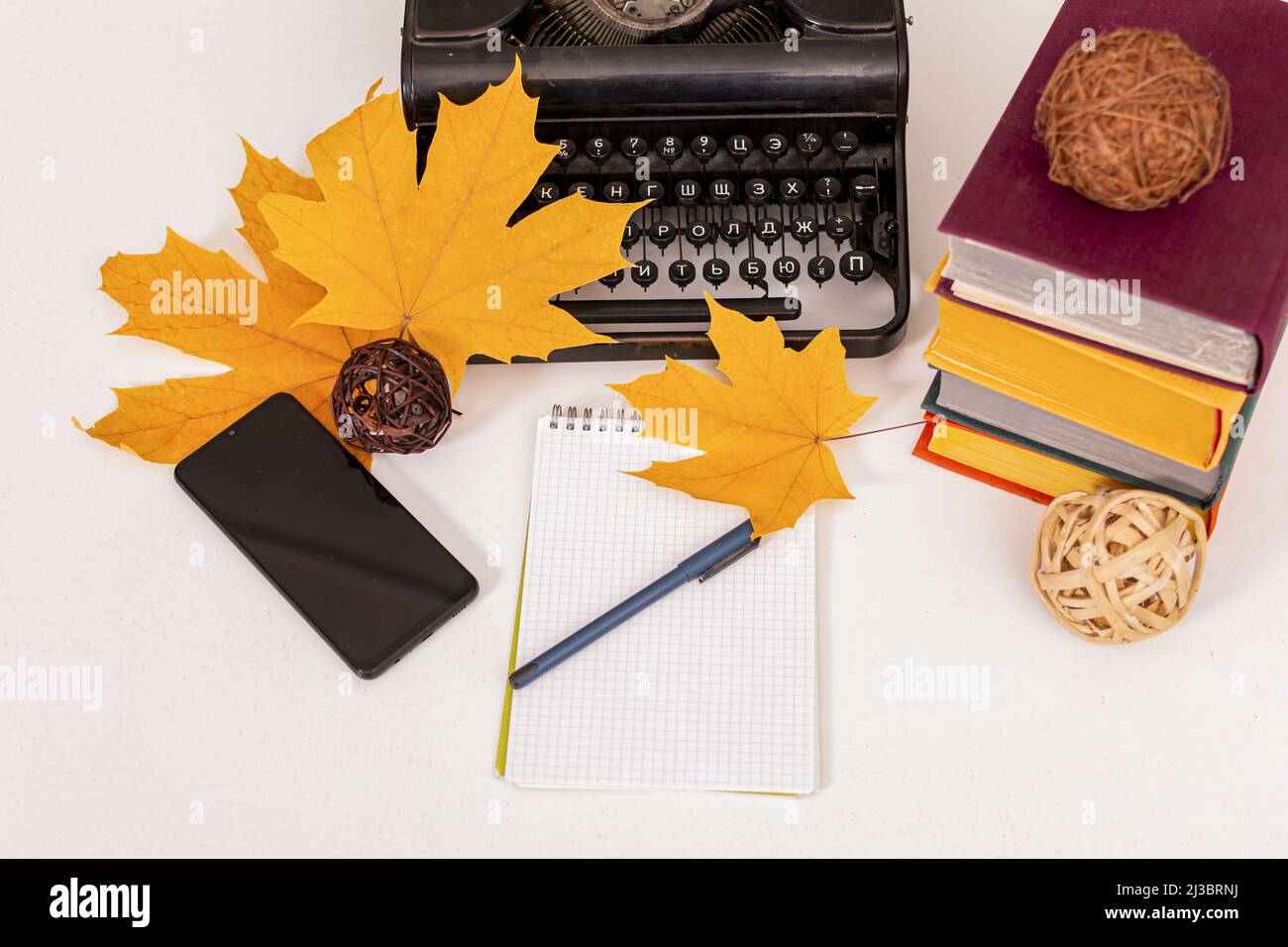 Autumn mood. On table are old typewriter, modern mobile phone, books ...