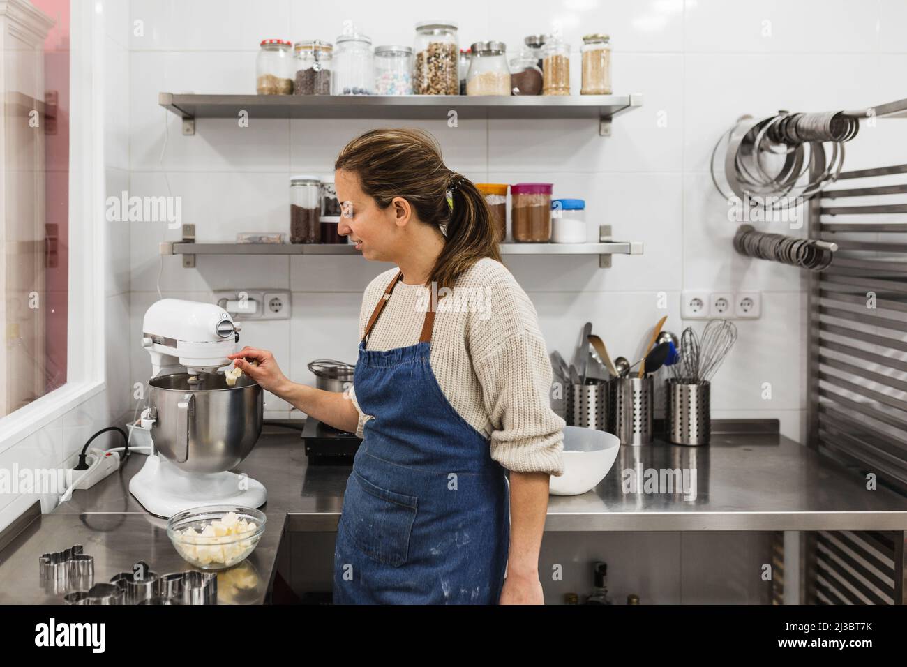 Pastry chef putting chunks of butter into a mixer Stock Photo - Alamy