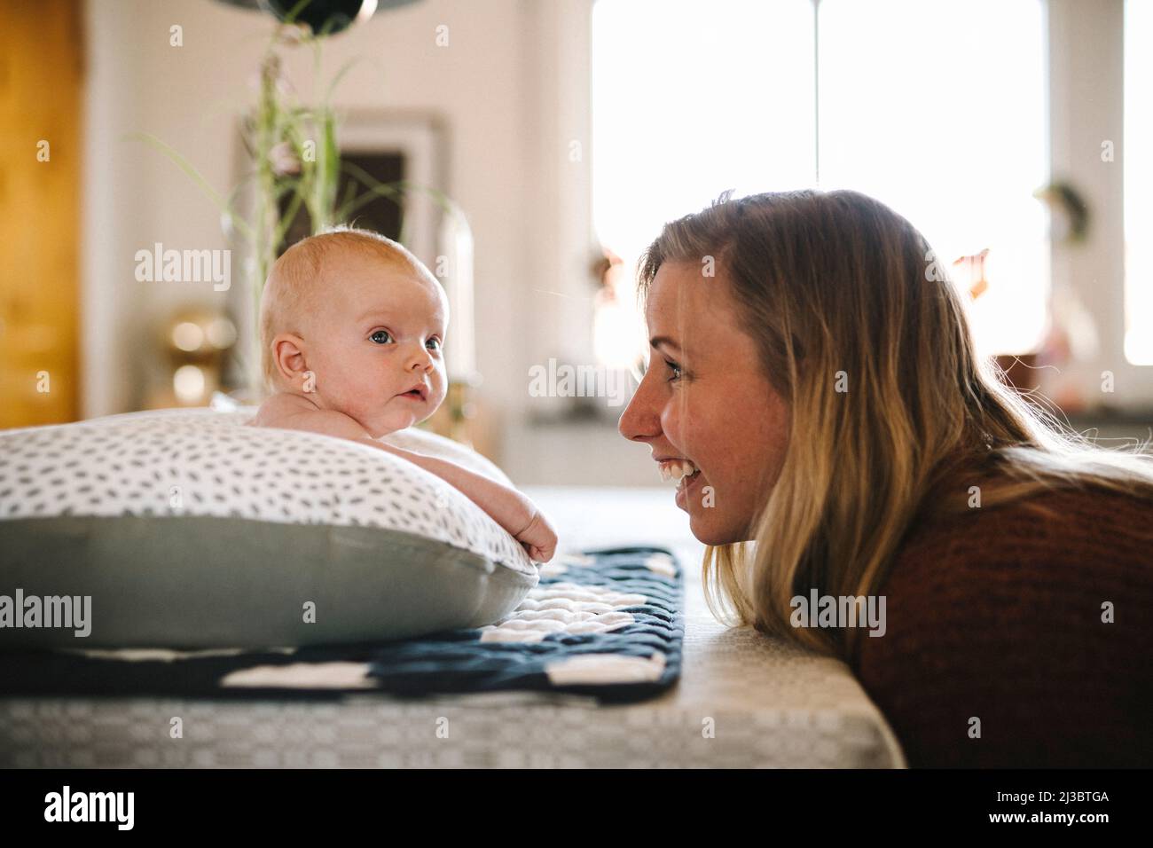 Young mother smiling to newborn baby Stock Photo - Alamy