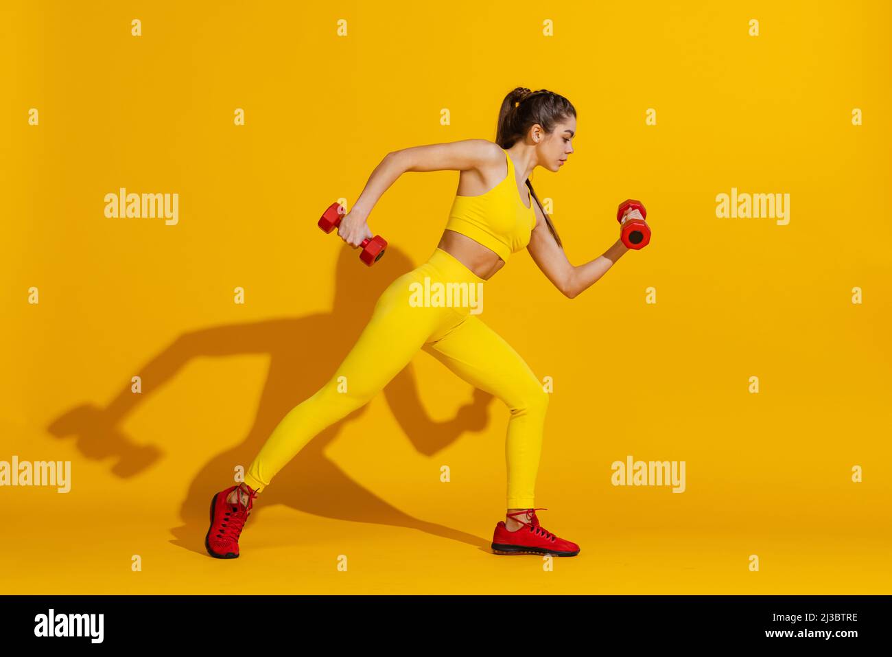 Studio shot of sportive slim girl workout with sports equipment ...