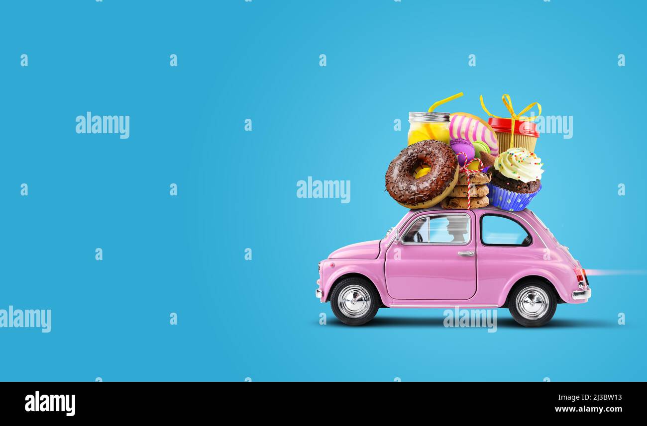 Pink retro car with Cakes, sweets, pastries a top on a blue Stock Photo ...