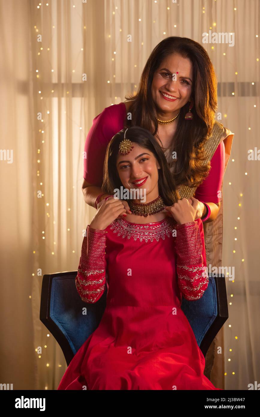 Young girl sitting on chair and mother holding her from backside Stock ...