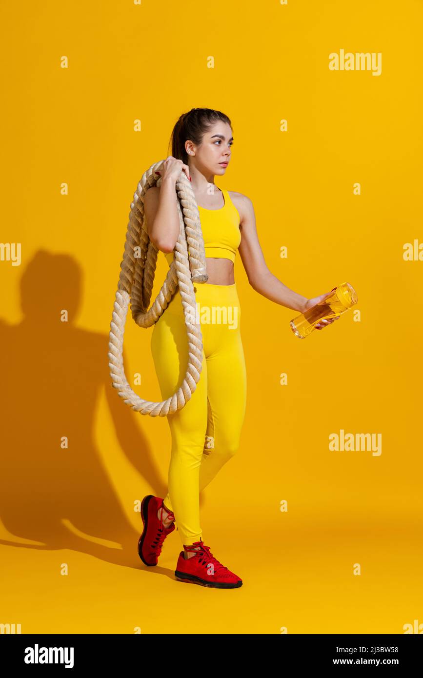 Studio shot of sportive slim girl workout with sports equipment ...