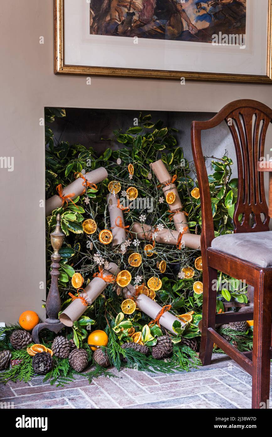 Christmas crackers and sliced orange display in fireplace of 18th ...