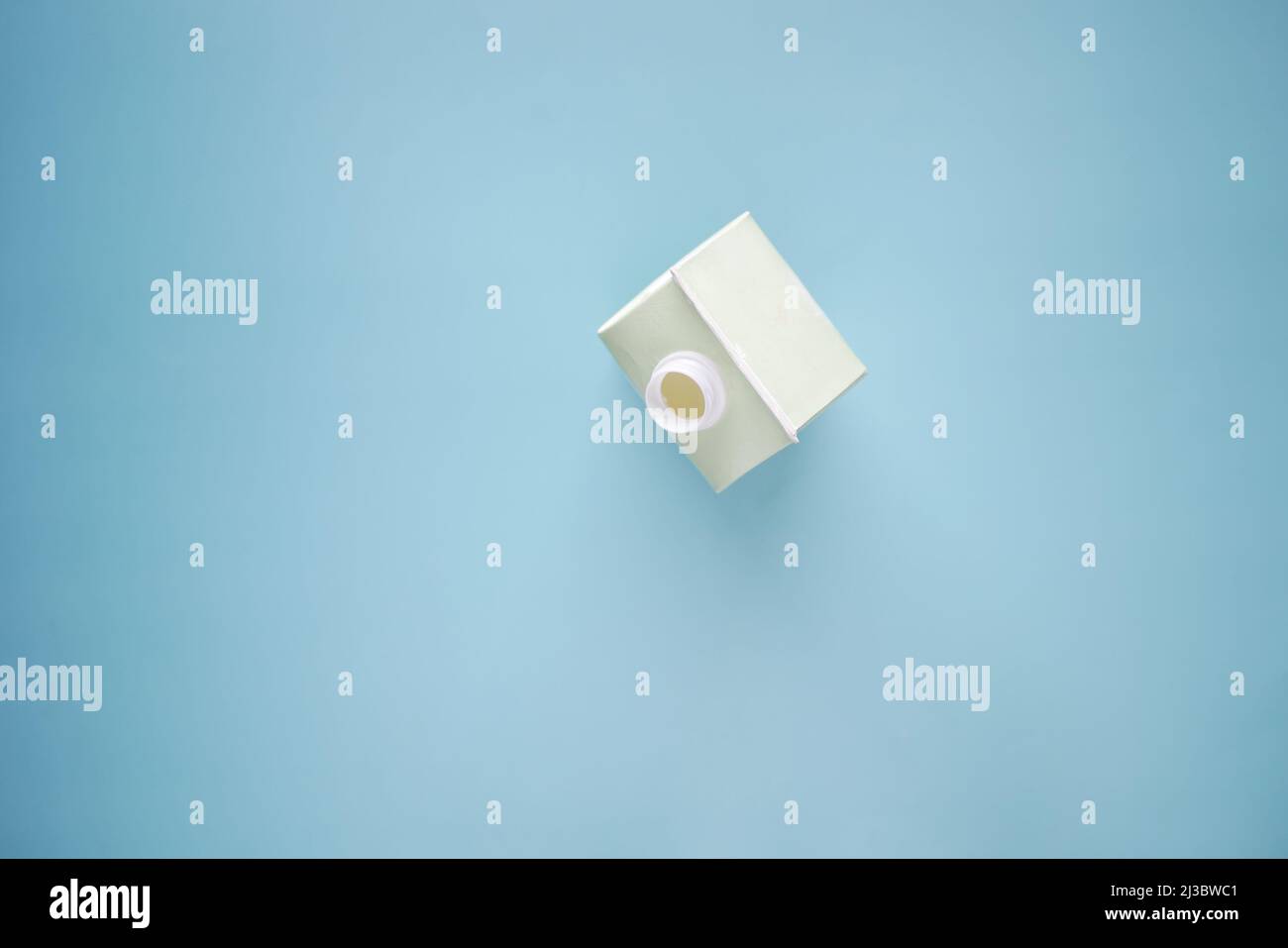 top view of a milk container on light green background Stock Photo - Alamy