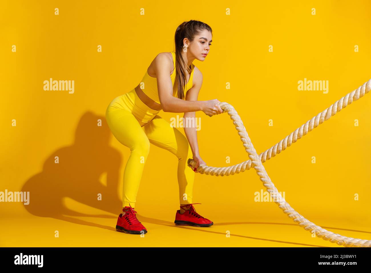 Studio shot of sportive slim girl workout with sports equipment ...