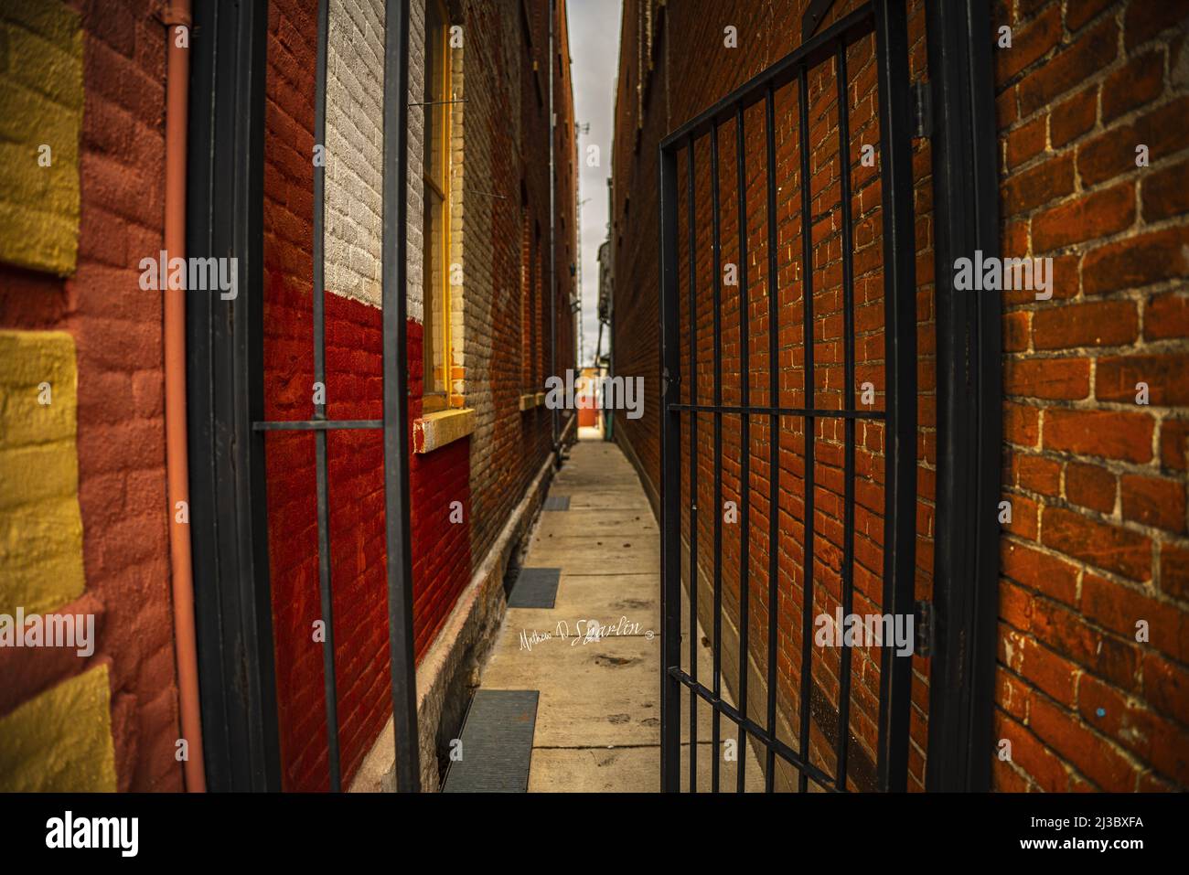 A view of an alleyway with colorful walls from both sides and an ...
