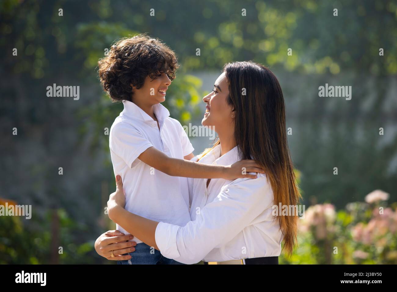 Mother hugging and caressing her son in park Stock Photo - Alamy