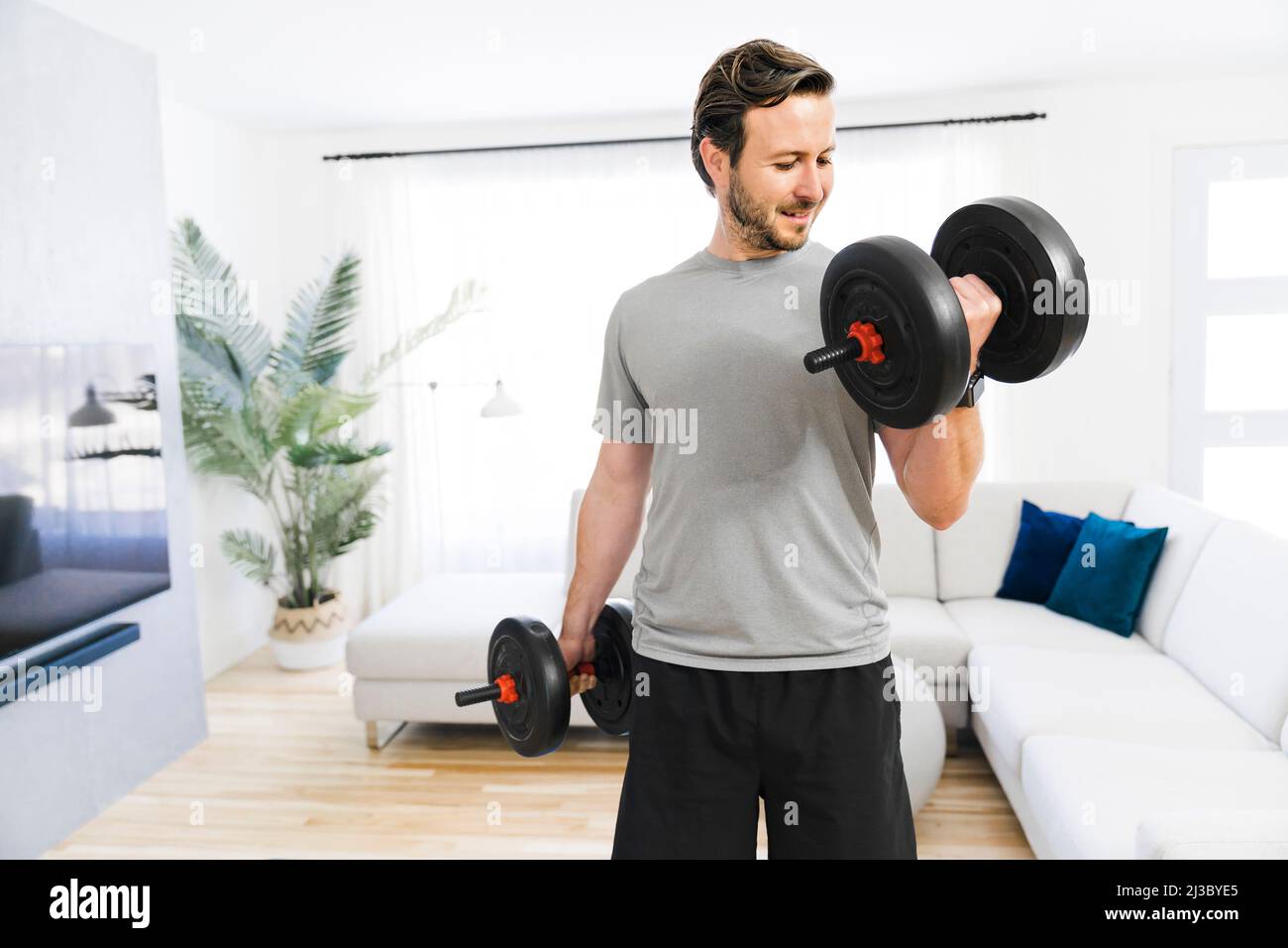 Athletic man home dumbell hi-res stock photography and images - Alamy