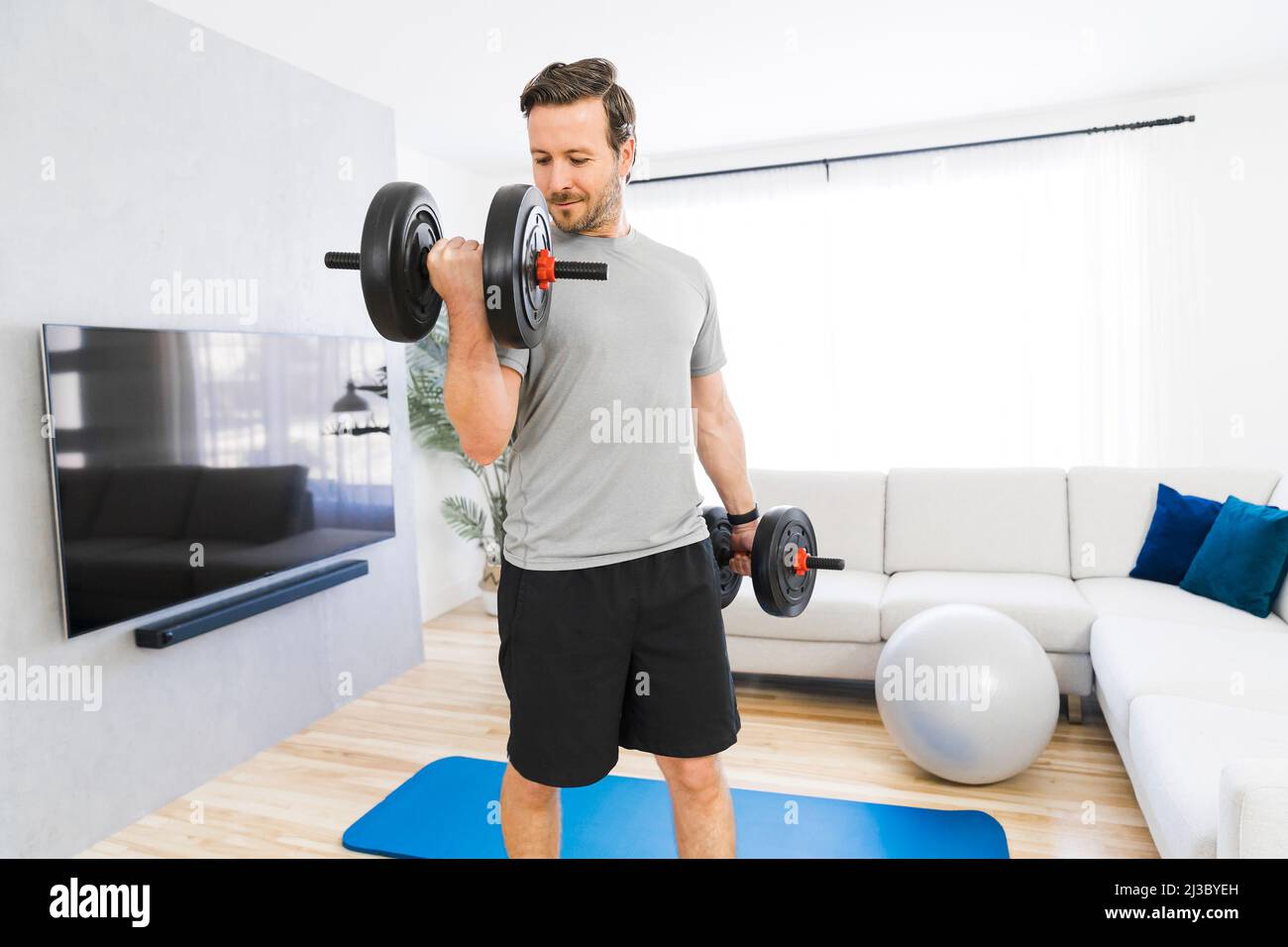 Athletic man home dumbell hi-res stock photography and images - Alamy