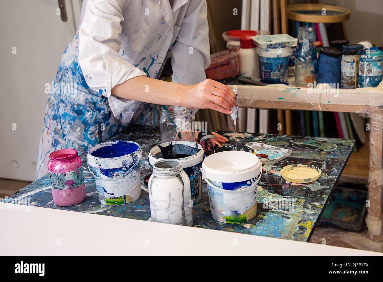 Close up of painter hands squeezing paint from tube on table wearing ...