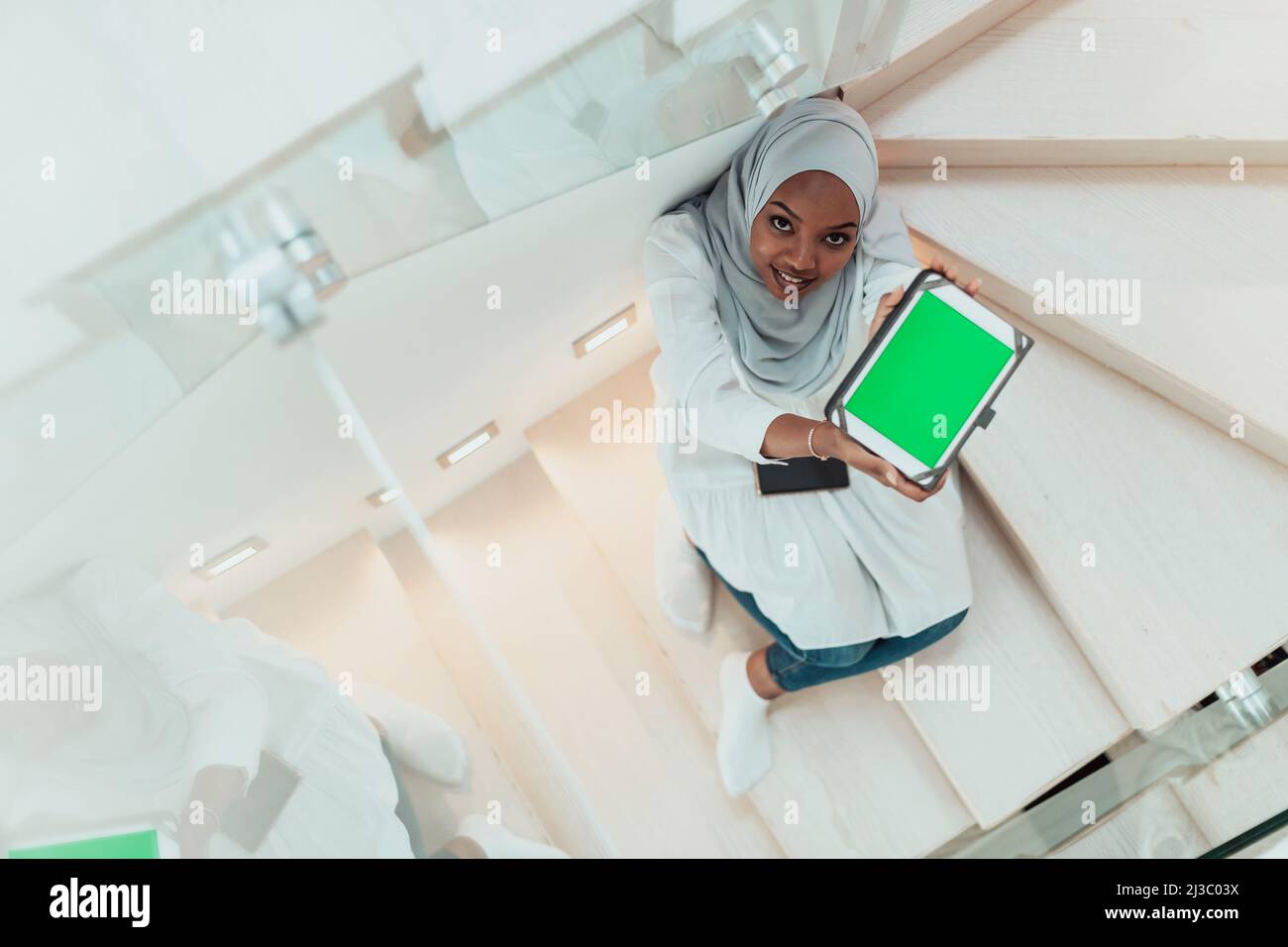 Young african modern muslim woman using tablet computer while sitting ...