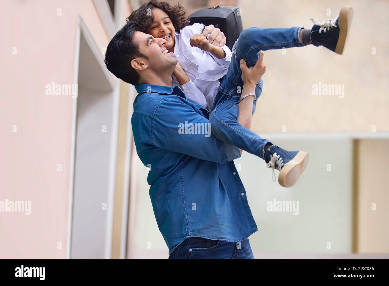 Father picking up and caressing his son wearing school uniform Stock ...